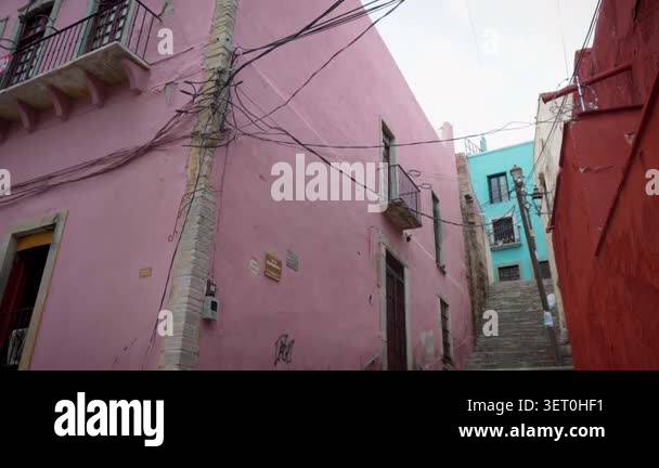 Vibrant alley with pink, red, and blue buildings in Guanajuato. Stairs ...
