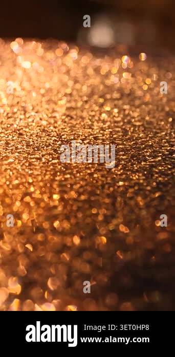 Rain drops on wet glass surface in warm yellow orange lamp light ...
