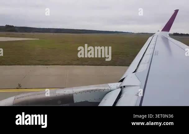 Passenger window view of a commercial aircraft during takeoff, showing ...