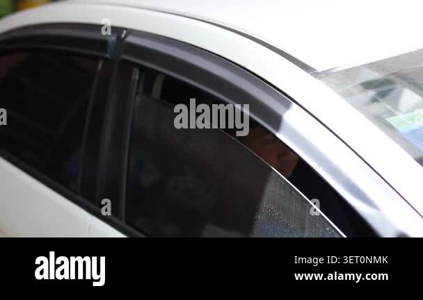 Asian man in his car slide car mirror and look at camera with happy ...
