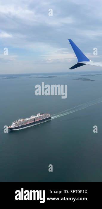 4K vertical POV footage from an airplane window featuring a cruise ship ...