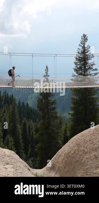 Vertical video footage of a lone hiker with a backpack confidently ...