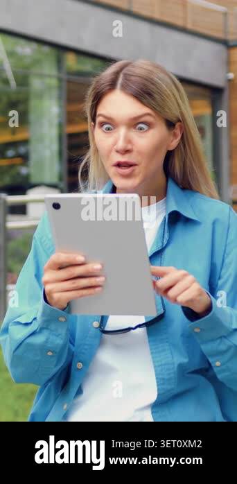 Close up of amazed woman holds digital tablet reading good news, happy ...