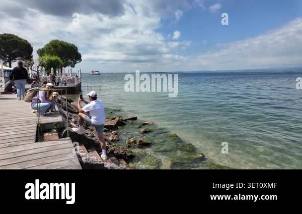 Bardolino, Italy - May 14, 2026 - People enjoying a sunny day by the ...