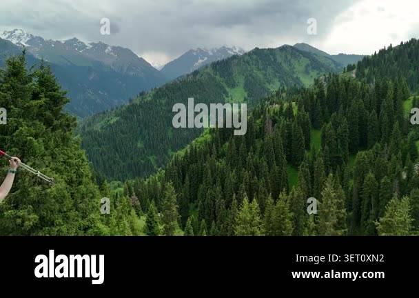 A lone hiker stands triumphantly atop a massive granite boulder, arms ...