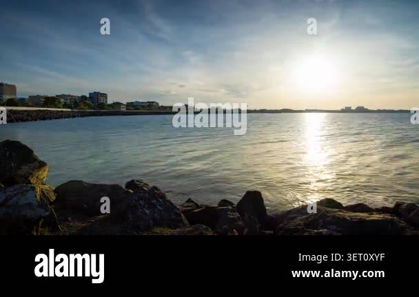The embankment with rocky small dark stones passes over the bay of a ...