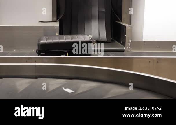 Luggage moving on a conveyor belt at an airport baggage claim area ...