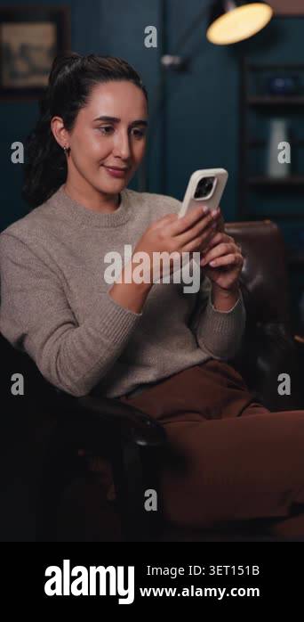Portrait of tranquil woman watches online content via smartphone at ...