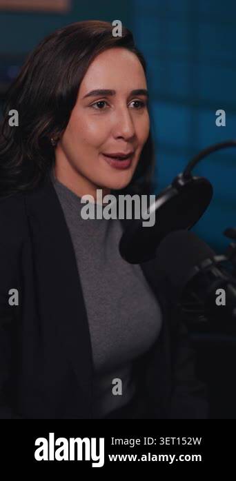 Portrait of pretty woman conducts podcast show in audio studio vertical ...