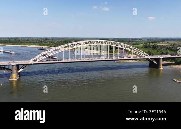 Expansive aerial view slowly revealing the waalbrug, a historic arch ...