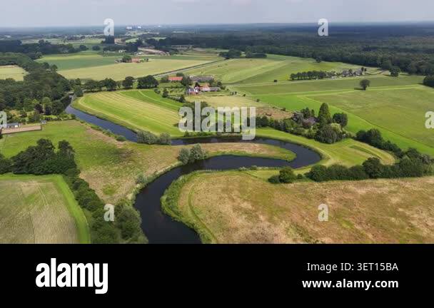 High aerial view showing a winding river flowing through a patchwork of ...