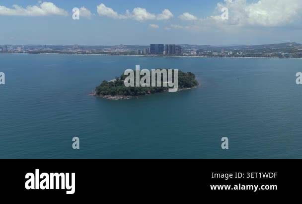 Aerial turning view of a lush, forested island seen from the side, set ...