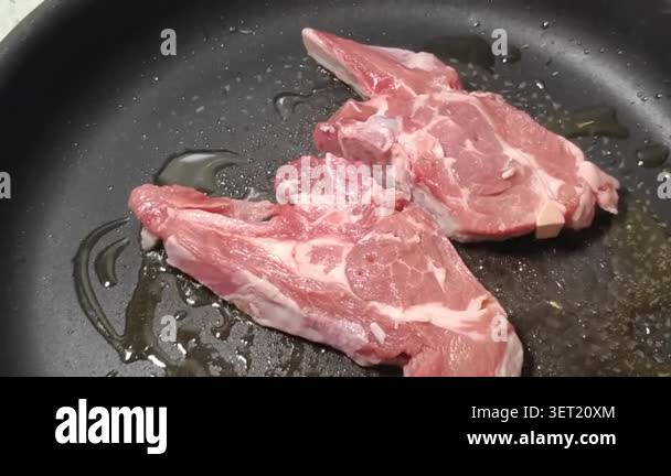 lamb chops cooking in a pan Stock Video Footage - Alamy