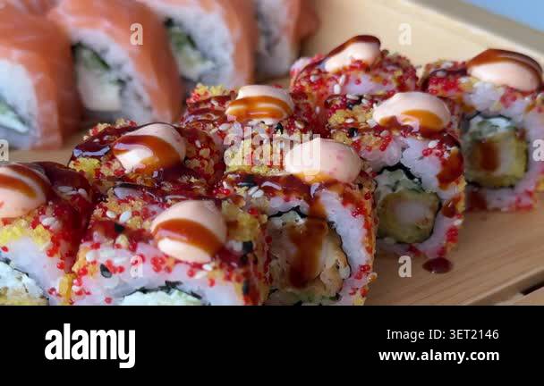 Fresh sushi rolls topped with bright red tobiko creamy japanese ...