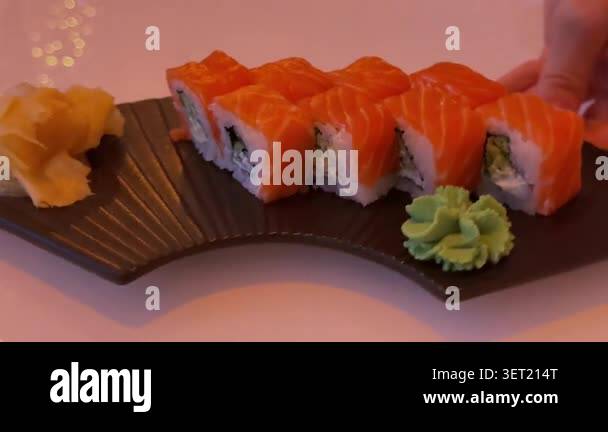 A female hand slowly rotates a black serving plate with Philadelphia ...