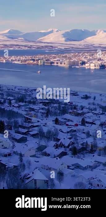 Soaring above the snow covered landscape of Norwegian town of Troms in ...