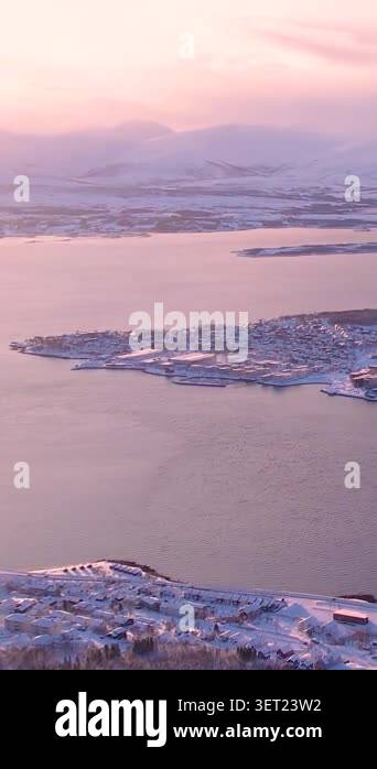 Soaring above the snow covered landscape of Norwegian town of Troms in ...