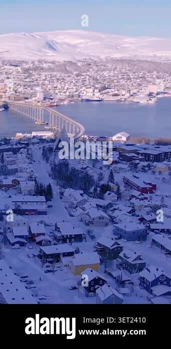 Soaring above the snow covered landscape of Norwegian town of Tromso in ...