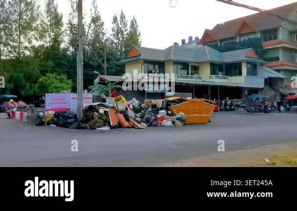 Overfilled trash containers on tropical street highlighting urban ...