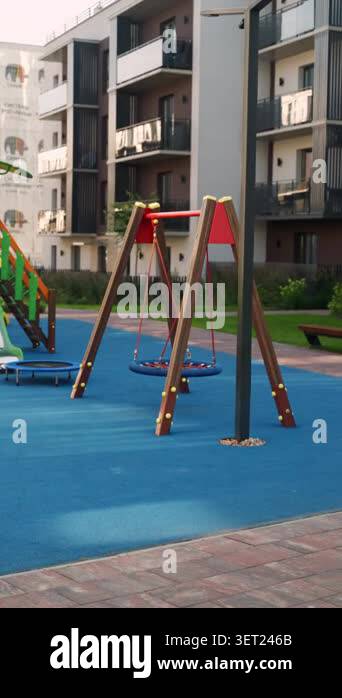 Empty modern childrens playground with swings and slides located in the ...