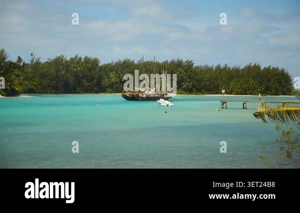 Turquoise beach lagoon, palm framing scene, solo traveler strolling ...
