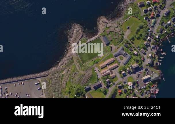 Drone footage of a picturesque Lofoten village featuring a green soccer ...