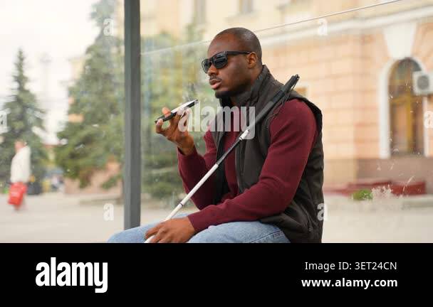 Man with visual impairment using voice recognition on his phone while ...