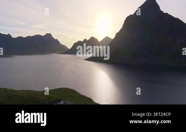 Serene sunset over Lofoten Islands' dramatic peaks reflected in calm ...