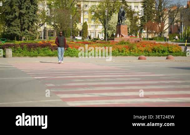 African american man with a visual impairment navigating a city park ...