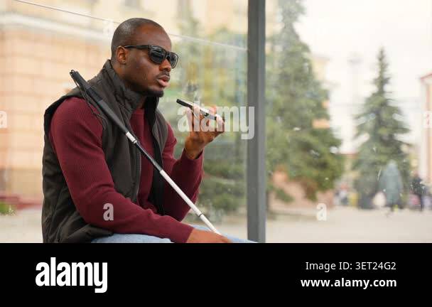 Visually impaired african american man in dark glasses with a walking ...