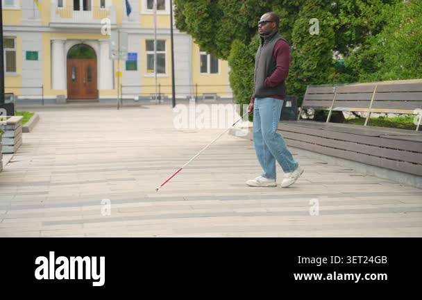 Independent african american man with a visual impairment using a long ...