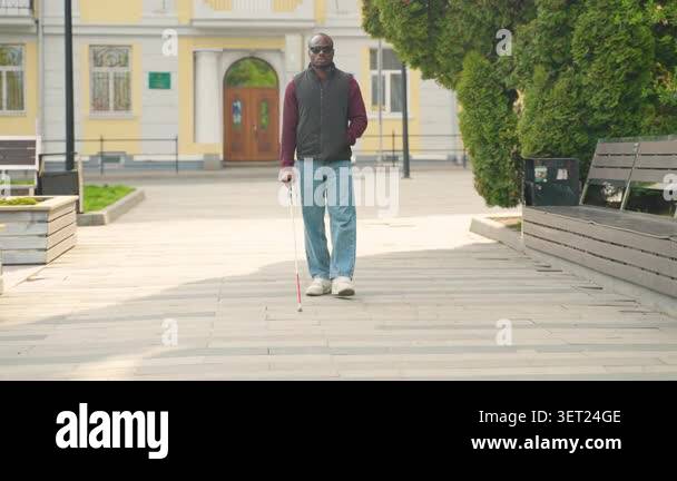 Independent man with a visual impairment navigating a city street. This ...