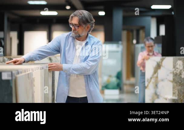 Focused senior couple choosing new ceramic tiles for their home ...