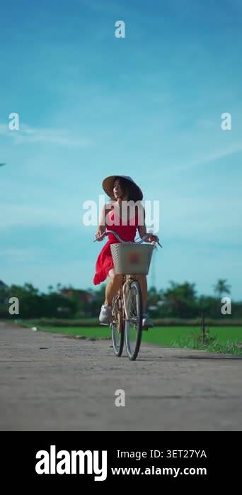 Girl riding bicycle in Vietnamese village with non la hat, Young woman ...
