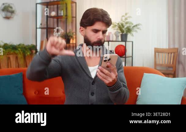 Indian man at home reads market drop news on smartphone worries about ...