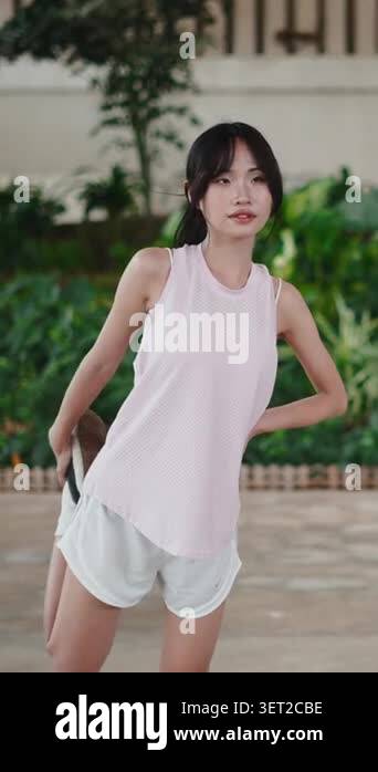 Young fit woman in sportswear doing a warm up exercise, stretching her ...
