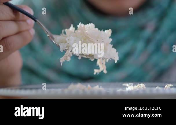 Person enjoys a plate of rice with shredded meat on a fork Stock Video ...