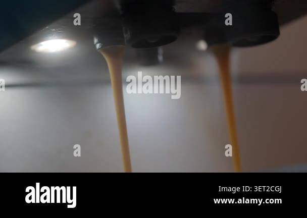 The shot shows coffee dripping from the machine in a busy cafe Stock ...