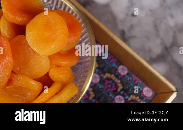 Dried apricots are in a bowl placed on a table with a design Stock ...