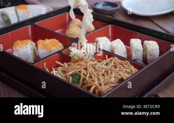 People eat sushi and noodles from a tray in a restaurant Stock Video ...