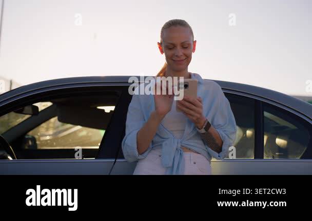 woman using mobile phone at car dealership Stock Video Footage - Alamy