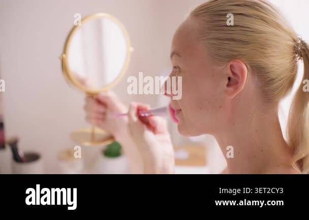 young woman applying makeup on her face Stock Video Footage - Alamy