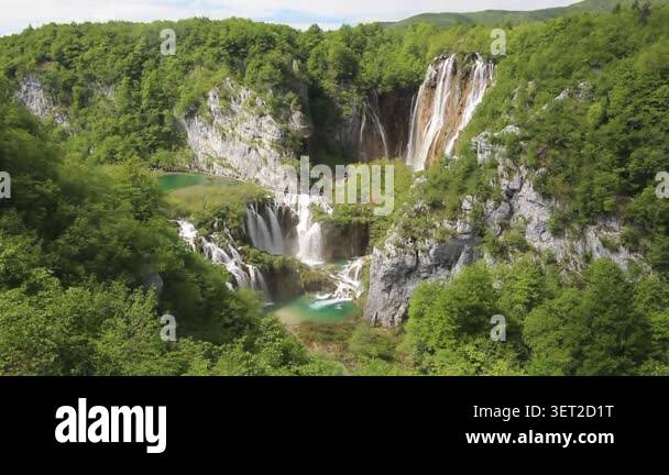 Beautiful cascading waterfalls flow down rocky cliffs surrounded by ...