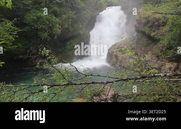 Powerful waterfall cascading into turquoise water surrounded by lush ...