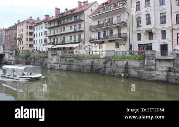 Tour boat moving down river past old European buildings with balconies ...