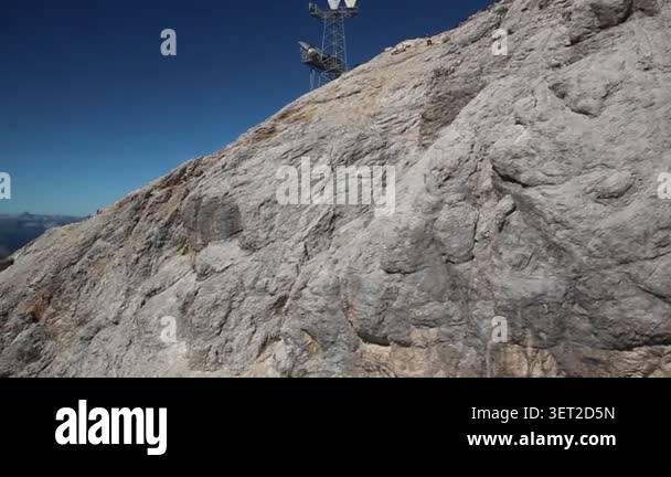 Aerial view of a rocky mountain slope with a communication tower on top ...