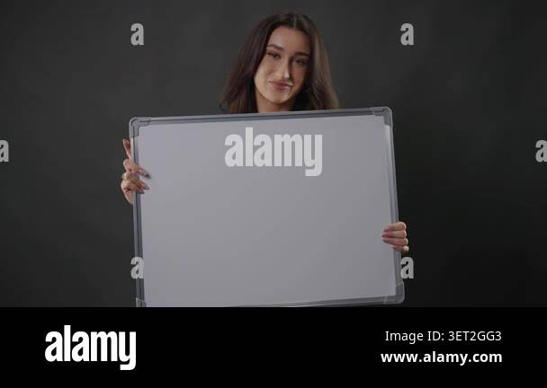 Young woman holding blank whiteboard for message or presentation, copy ...