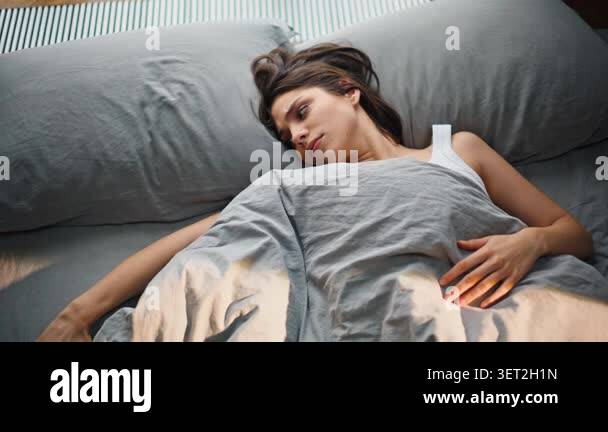 Young brunette sleeping pillow lying mattress closeup. Tired sleepy ...