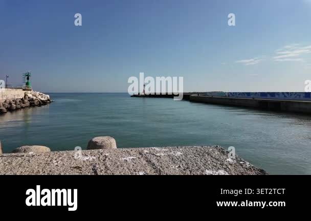 Calm Adriatic Sea with concrete breakwater and small lighthouse ...