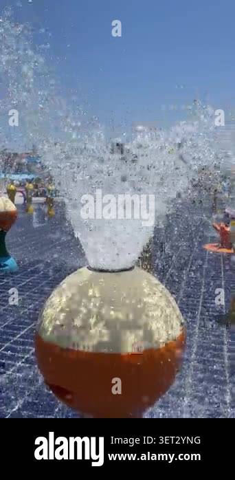 Sphere water fountain spraying liquid in a sunny outdoor water park ...